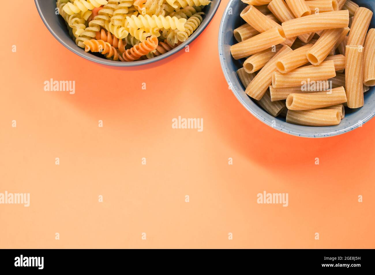 Top view of tri-color rotini and rigatoni pasta on a bowl isolated on ...