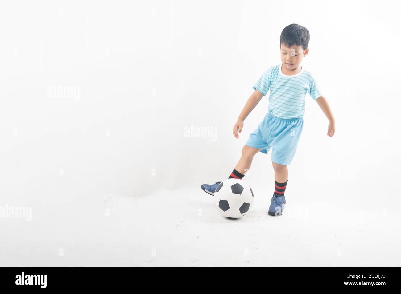 Young Asian boy kick football isolated on white background Stock Photo ...