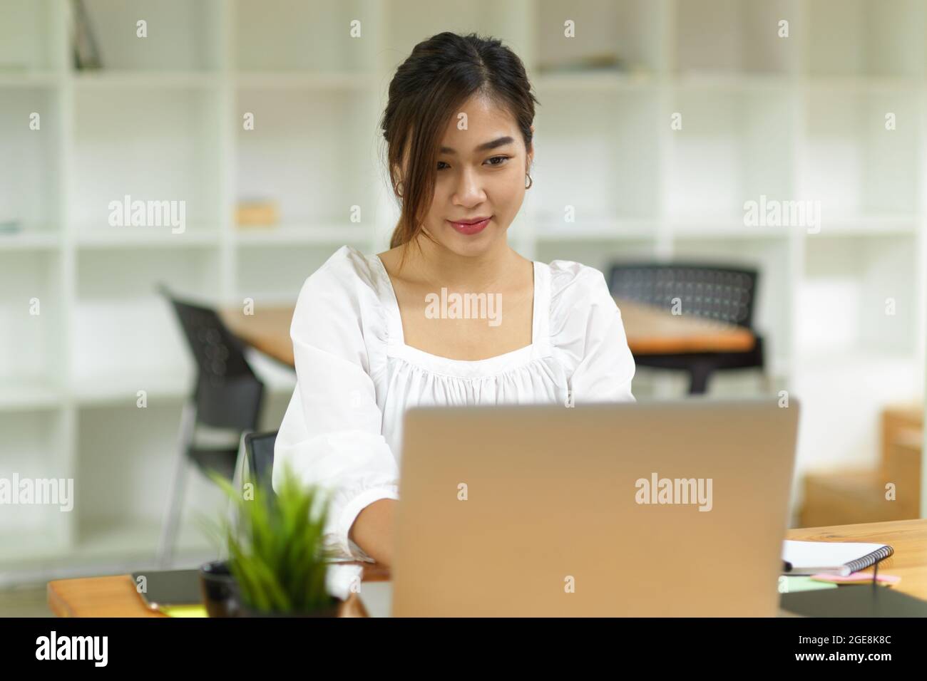 Beautiful female freelance auditor working with laptop at coffee shop ...