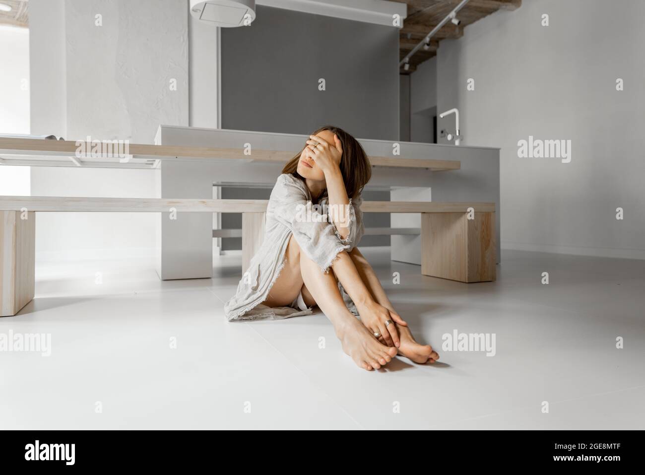 Sad woman sitting depressed alone at home Stock Photo - Alamy