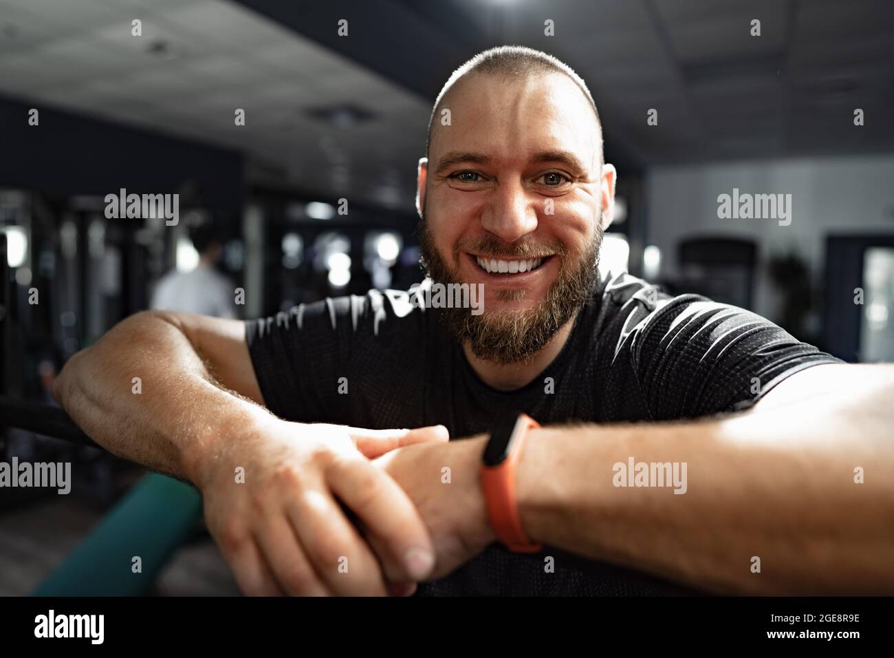 Cheerful smiling man bodybuilder standing in a gym Stock Photo - Alamy