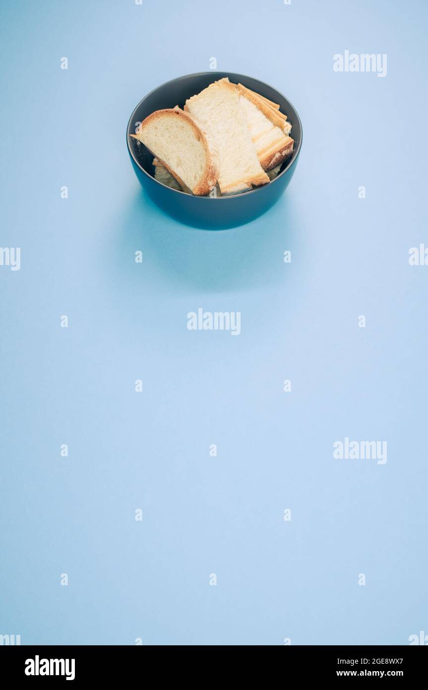 Vertical shot of bread slices on a bowl isolated on blbackground Stock ...