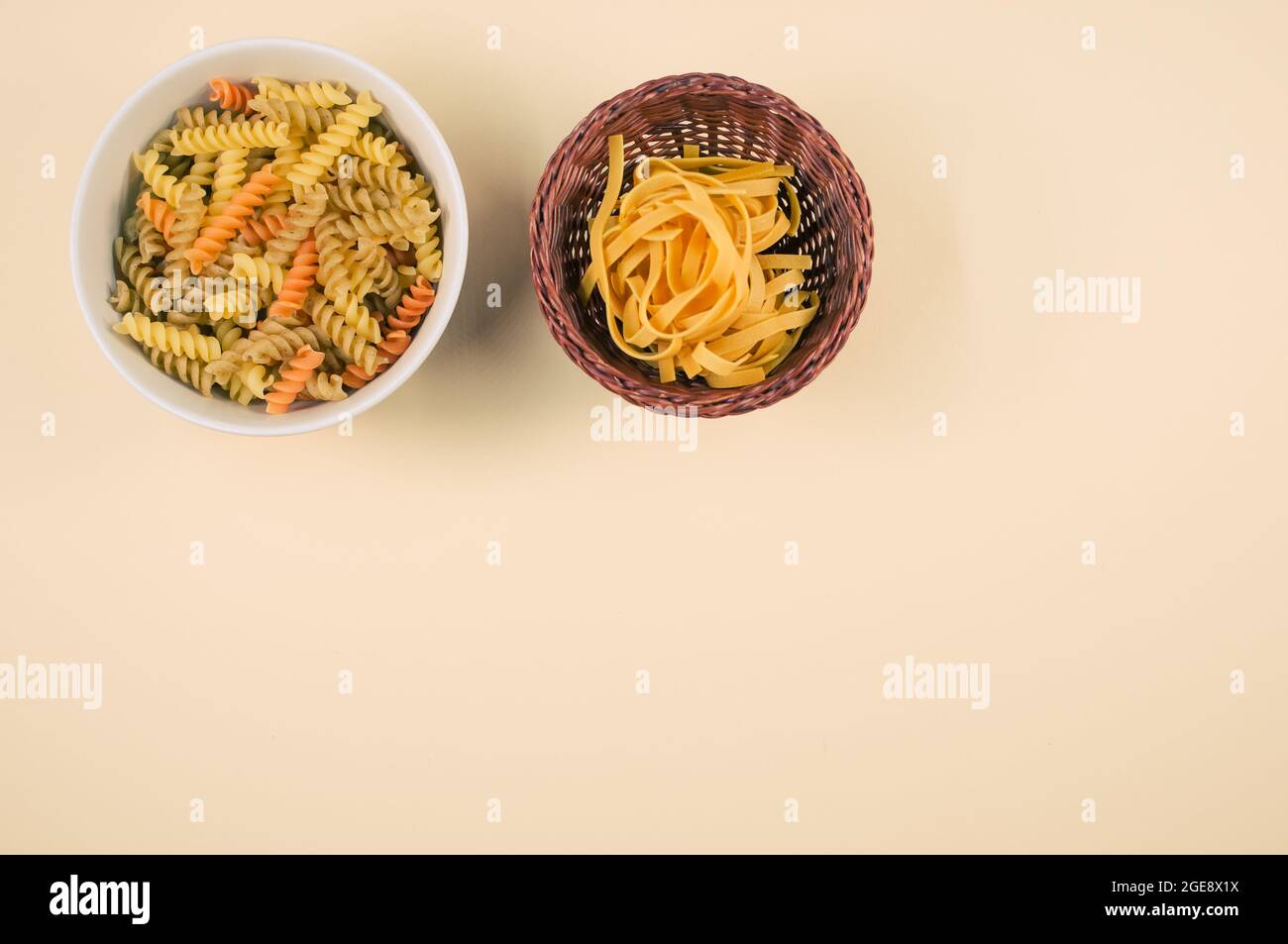 Top view of tri-color rotini and fettuccine pasta on a bowl isolated on ...