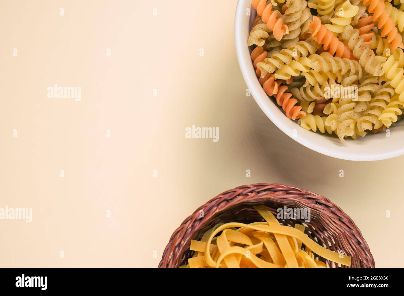 Top view of tri-color rotini and fettuccine pasta on a bowl isolated on ...
