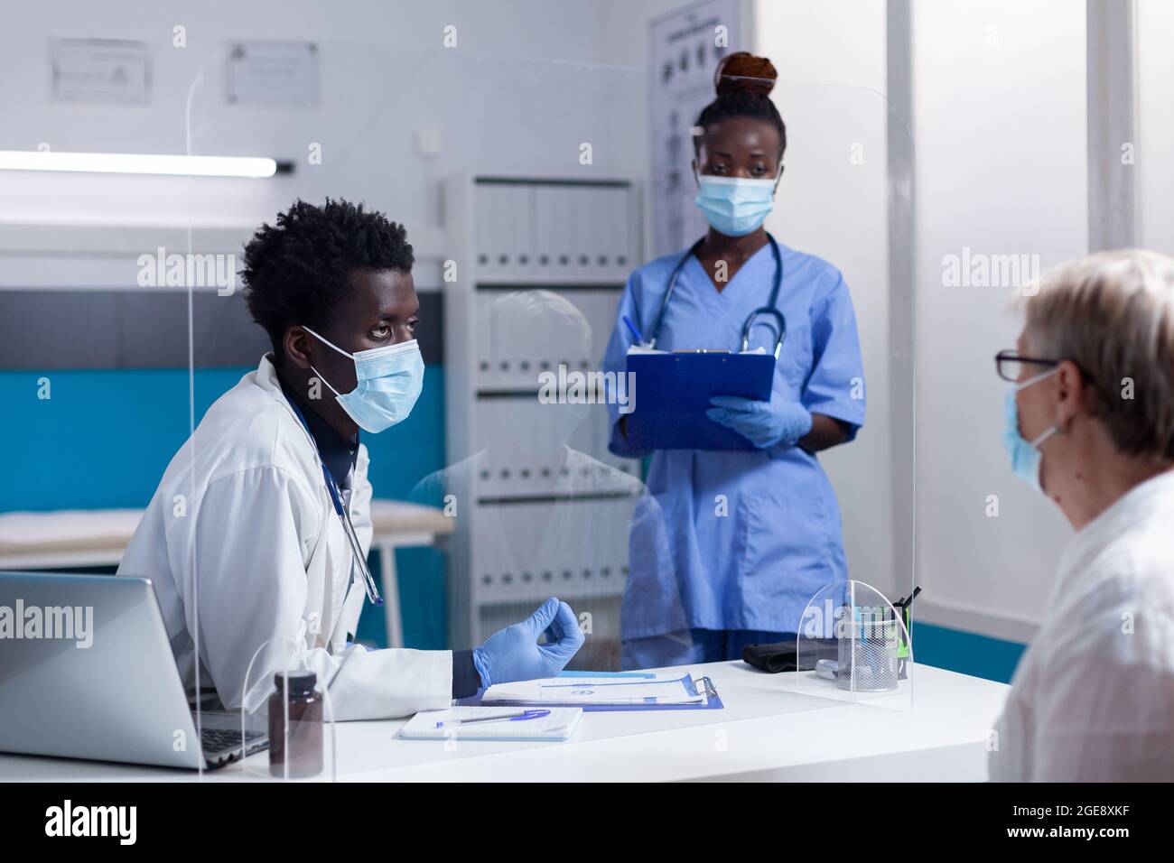 African american medical team talking to senior woman about healthcare ...