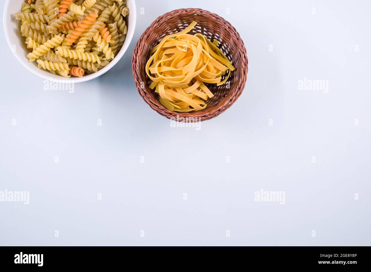 Top view of tri-color rotini and fettuccine pasta on a bowl isolated on ...