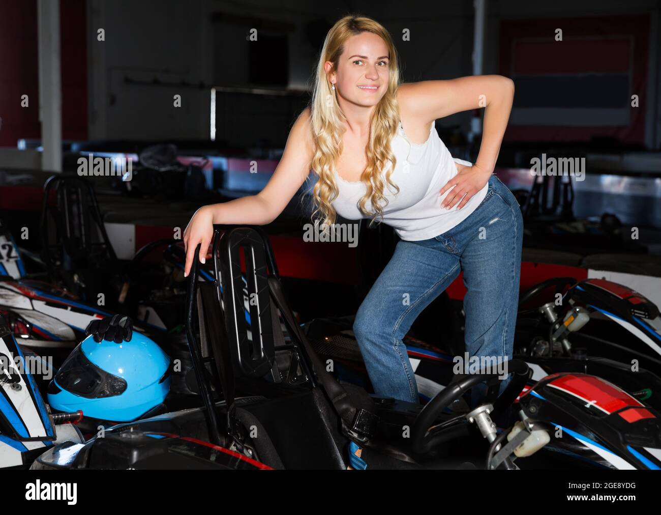 Positive female model posing near racing cars Stock Photo - Alamy