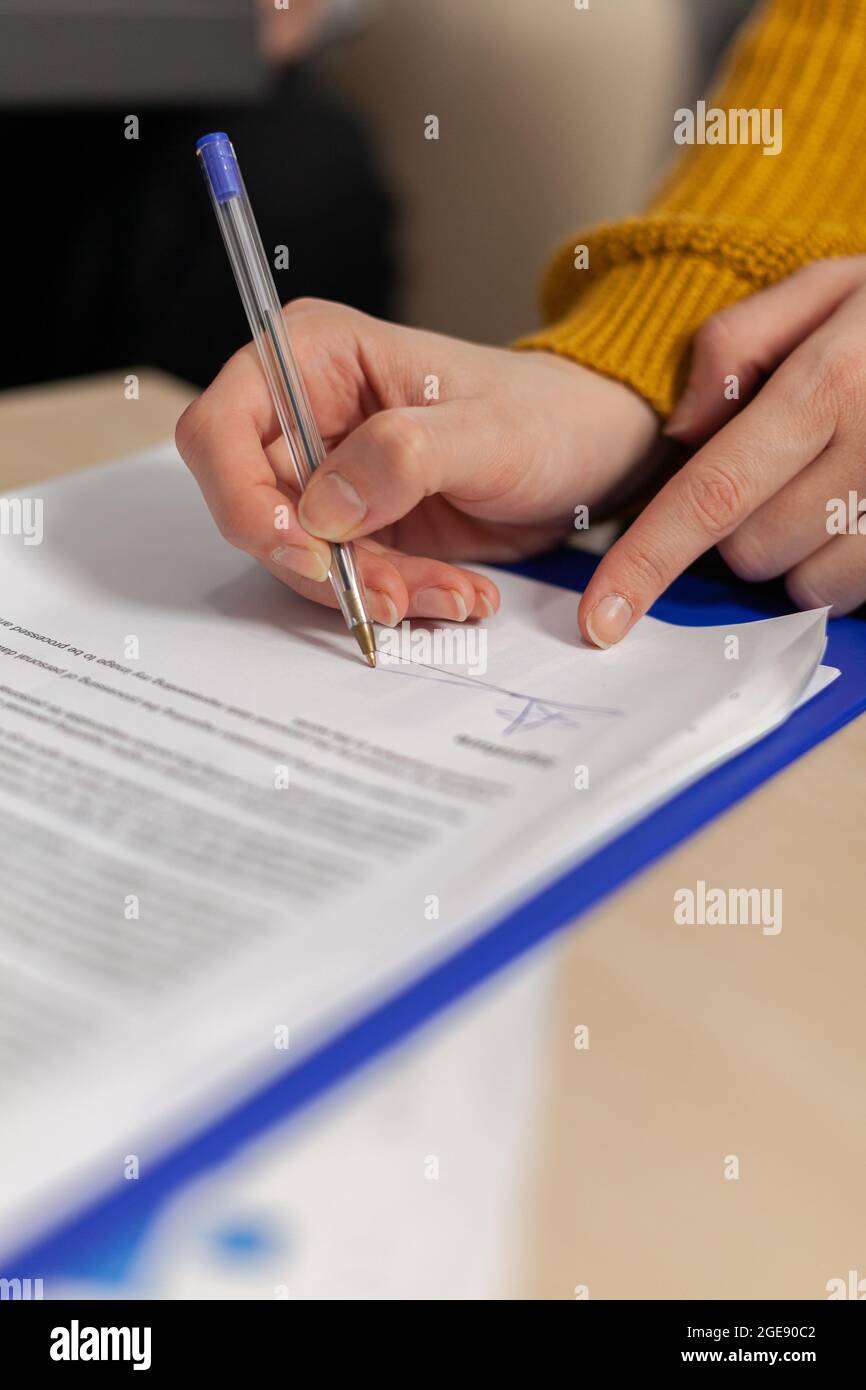 Businesswoman signing paper, partner hand puts signature on business ...