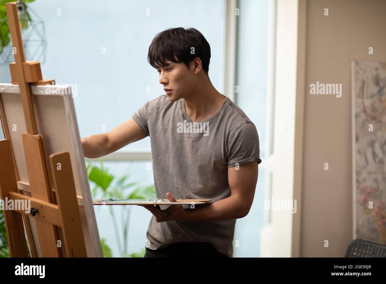 Young Chinese man painting at home Stock Photo - Alamy
