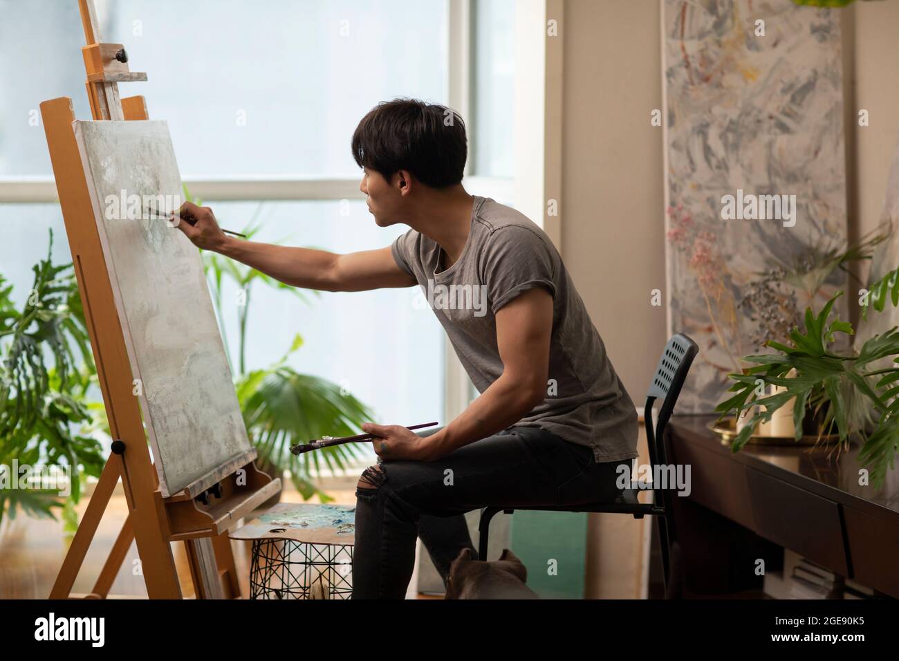 Young Chinese man painting at home Stock Photo - Alamy