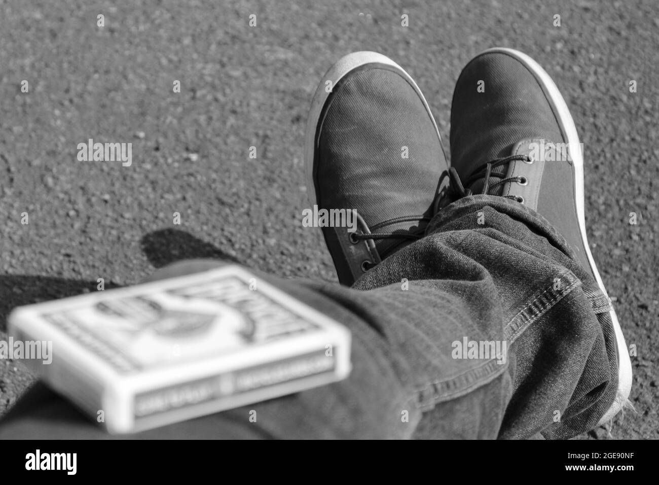 Greyscale shot of a box of a deck of cards on a person's leg Stock ...