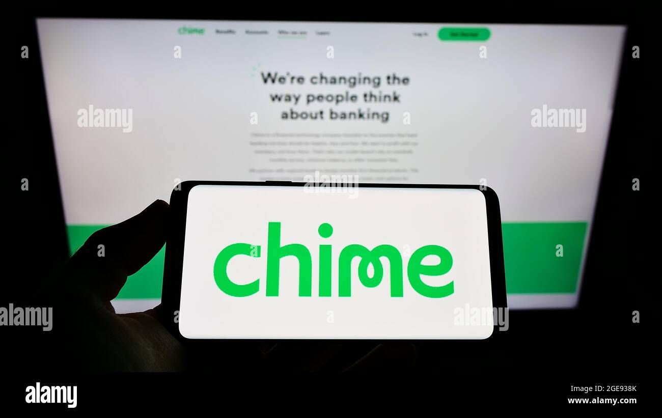 Person holding mobile phone with logo of US fintech company Chime ...