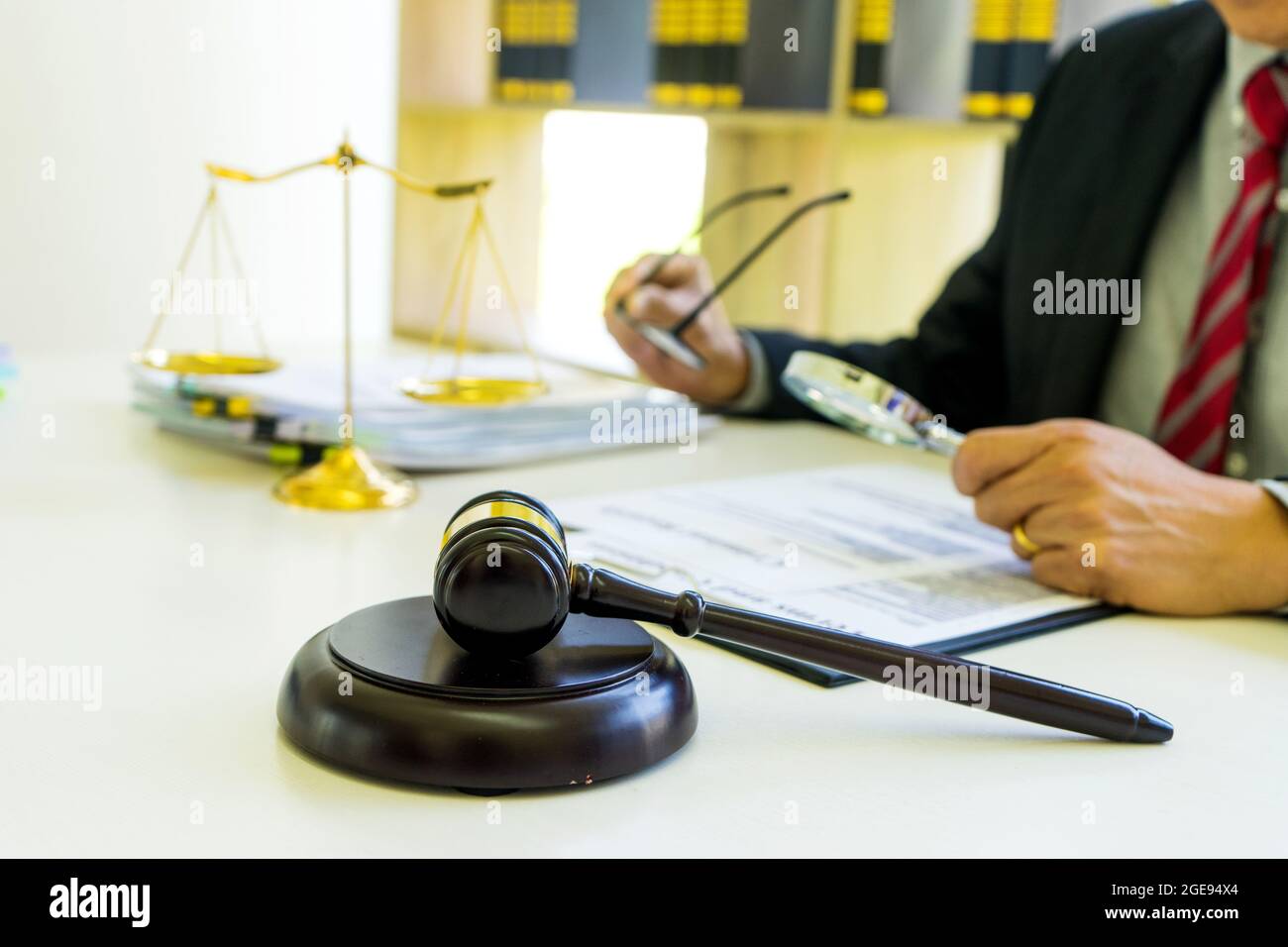 Lawyer or judge was looking at the document with a magnifying glass to ...