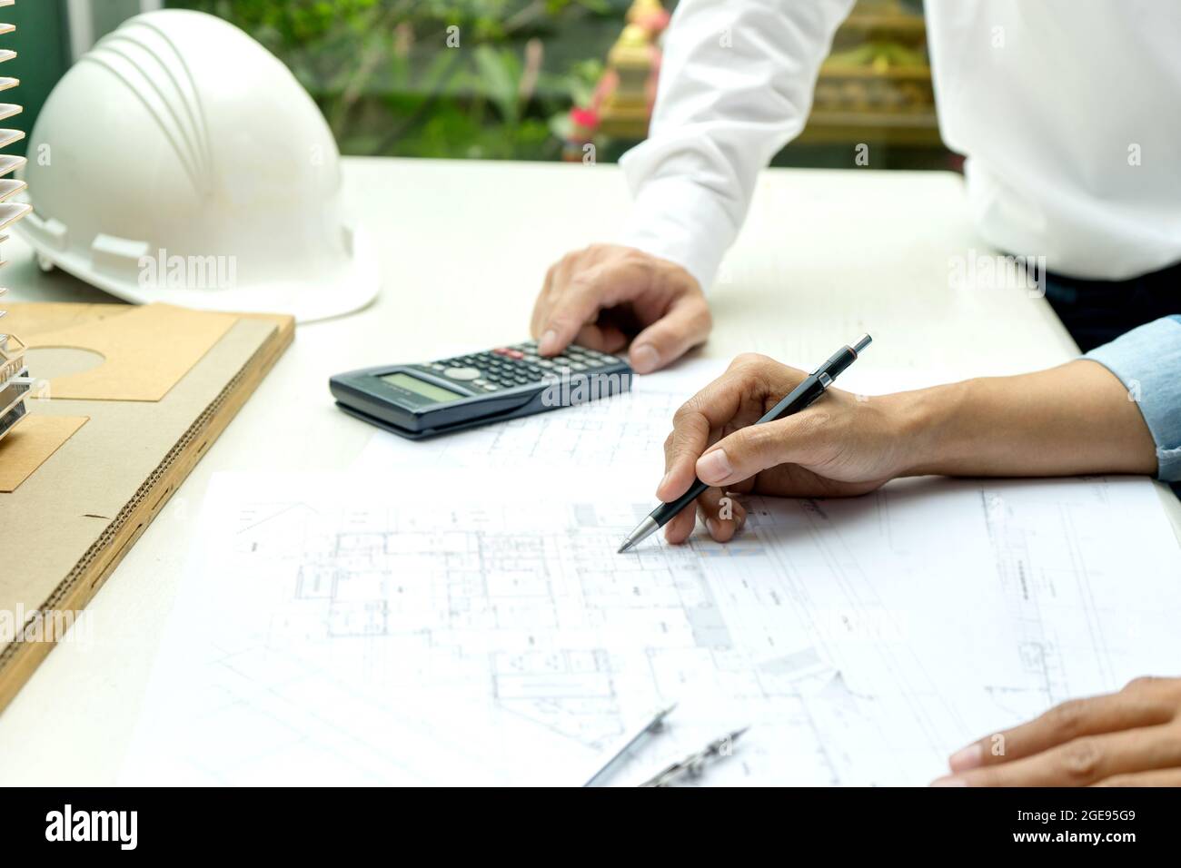 Engineers and architects are discussing and revising plans for building ...