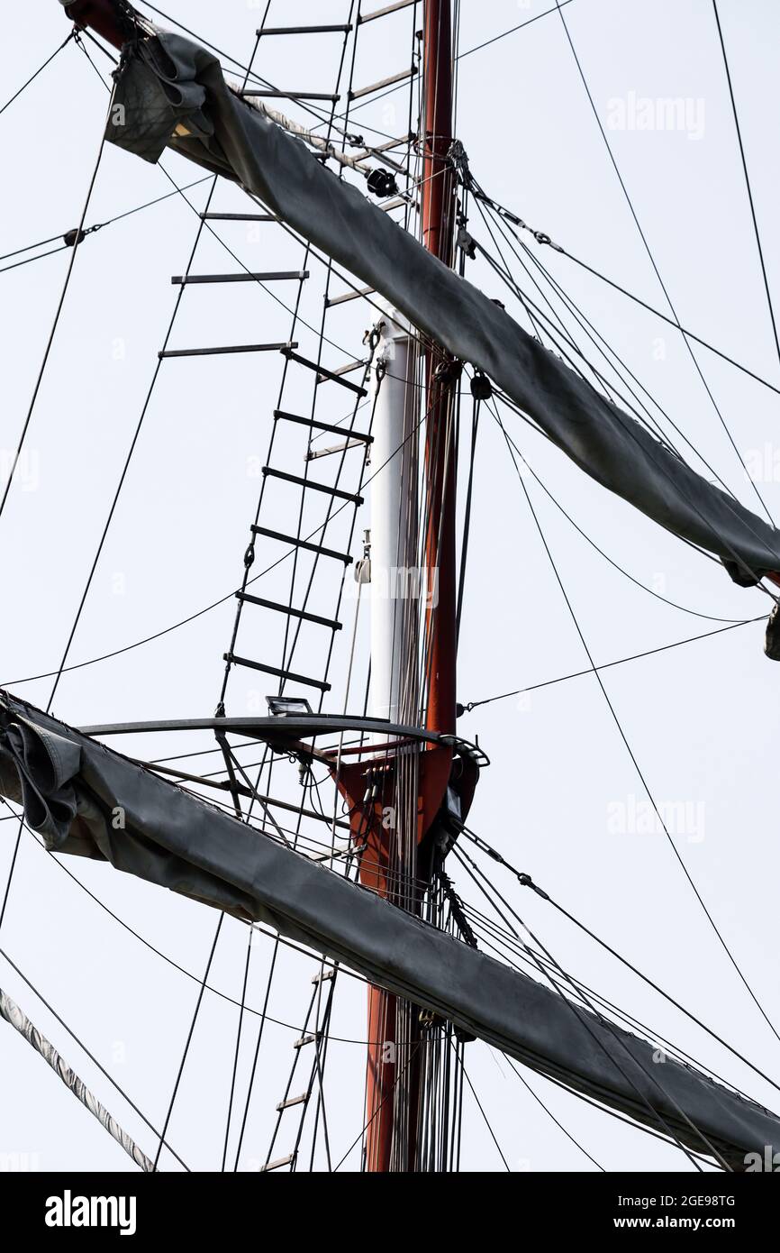 Vertical shot of masts spars and rigging on a tall ship in dock against ...