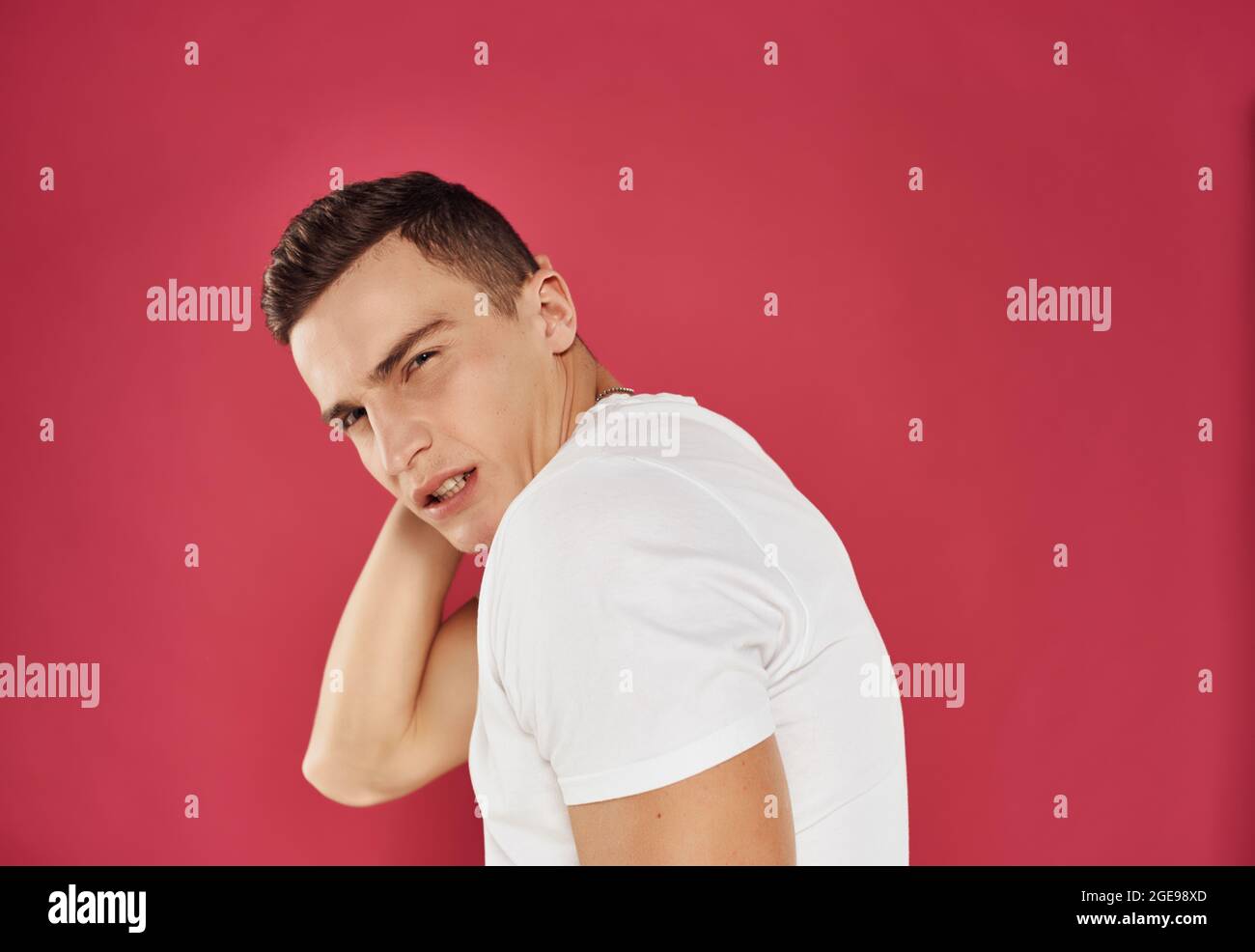 disgruntled man with an angry expression in a white t-shirt gesturing ...