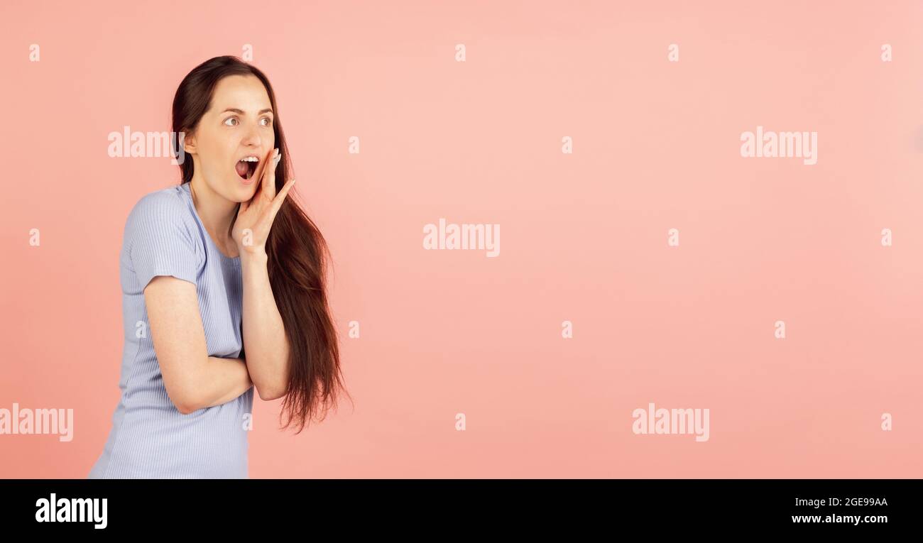 Gossip girl. Portrait of young Caucasian woman posing isolated on pink ...
