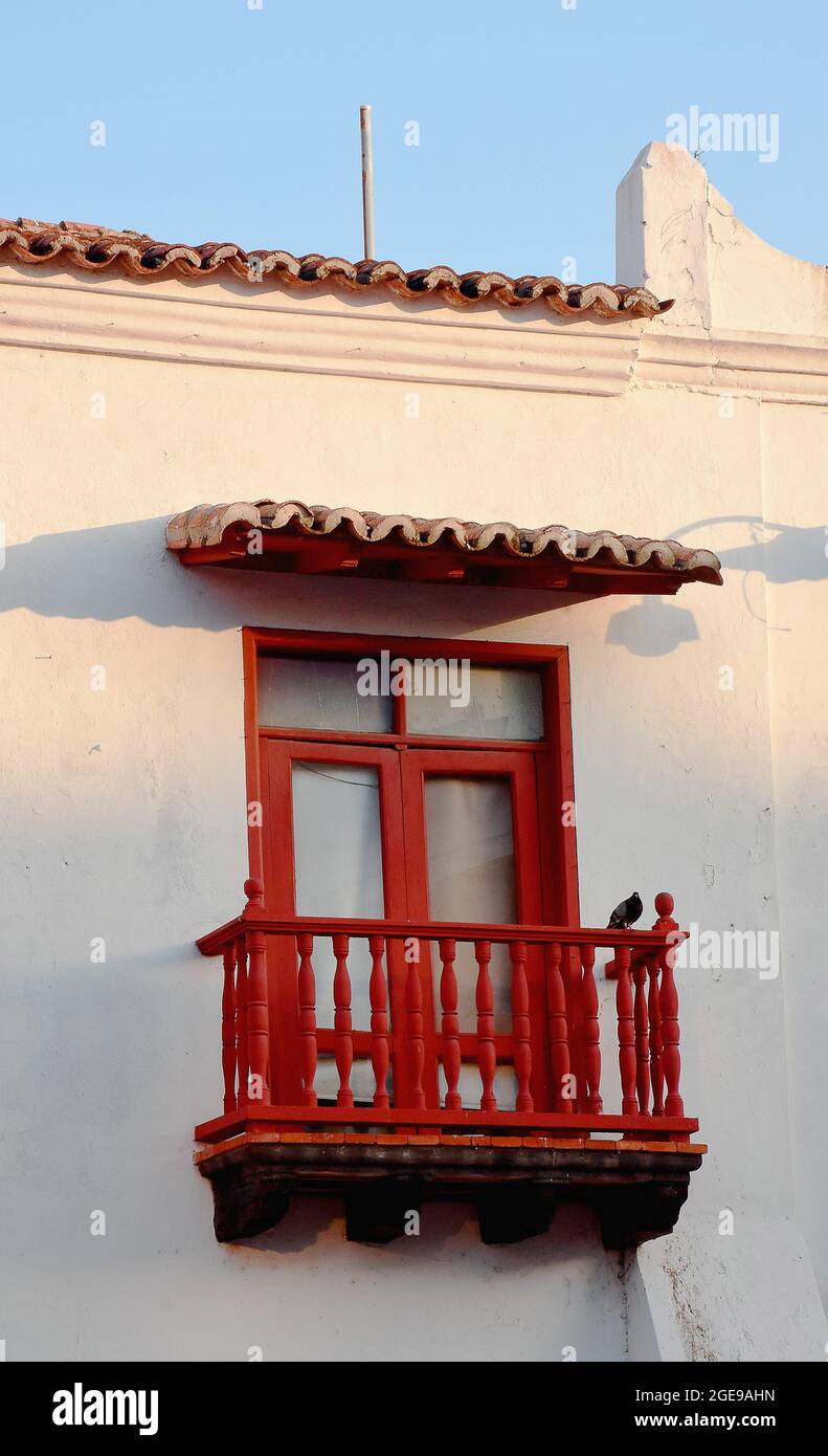 Vertical shot of a beautiful red balcony with a small roof in Cartagena ...