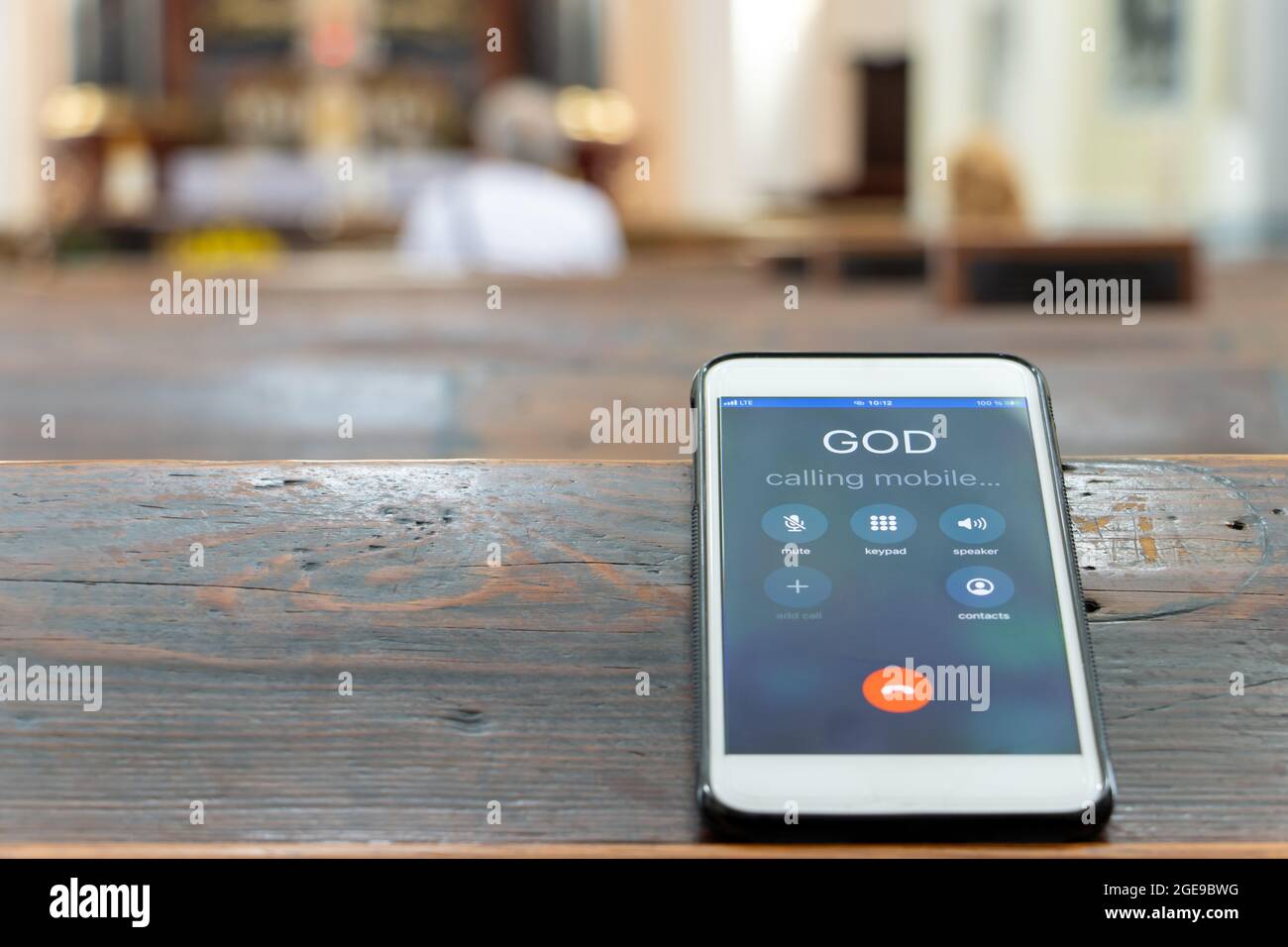 Calling God with a mobile phone on the table of a prayer bench in the ...
