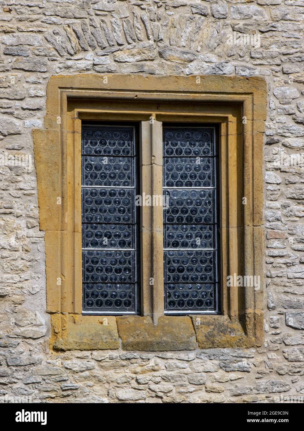 A window with decorative glass composed of small round glass plates in ...