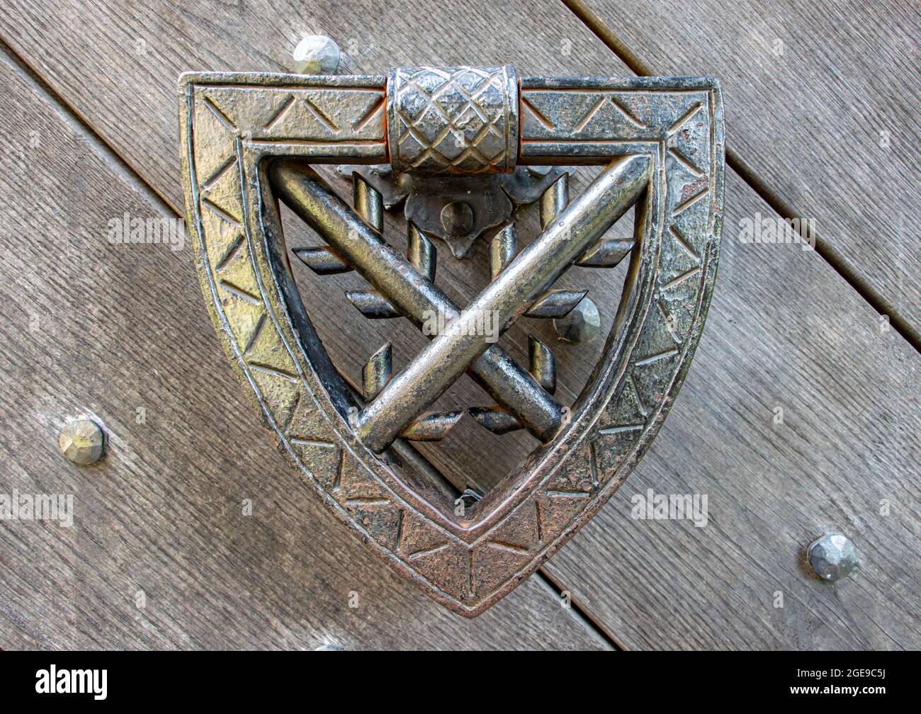 The iron knocker with the family coat of arms of an ancient ...