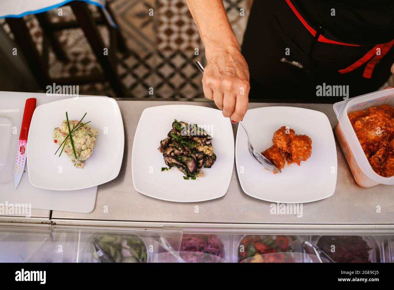 Hand making tapas, tomato meatballs, roasted garlic eggplants, potato ...