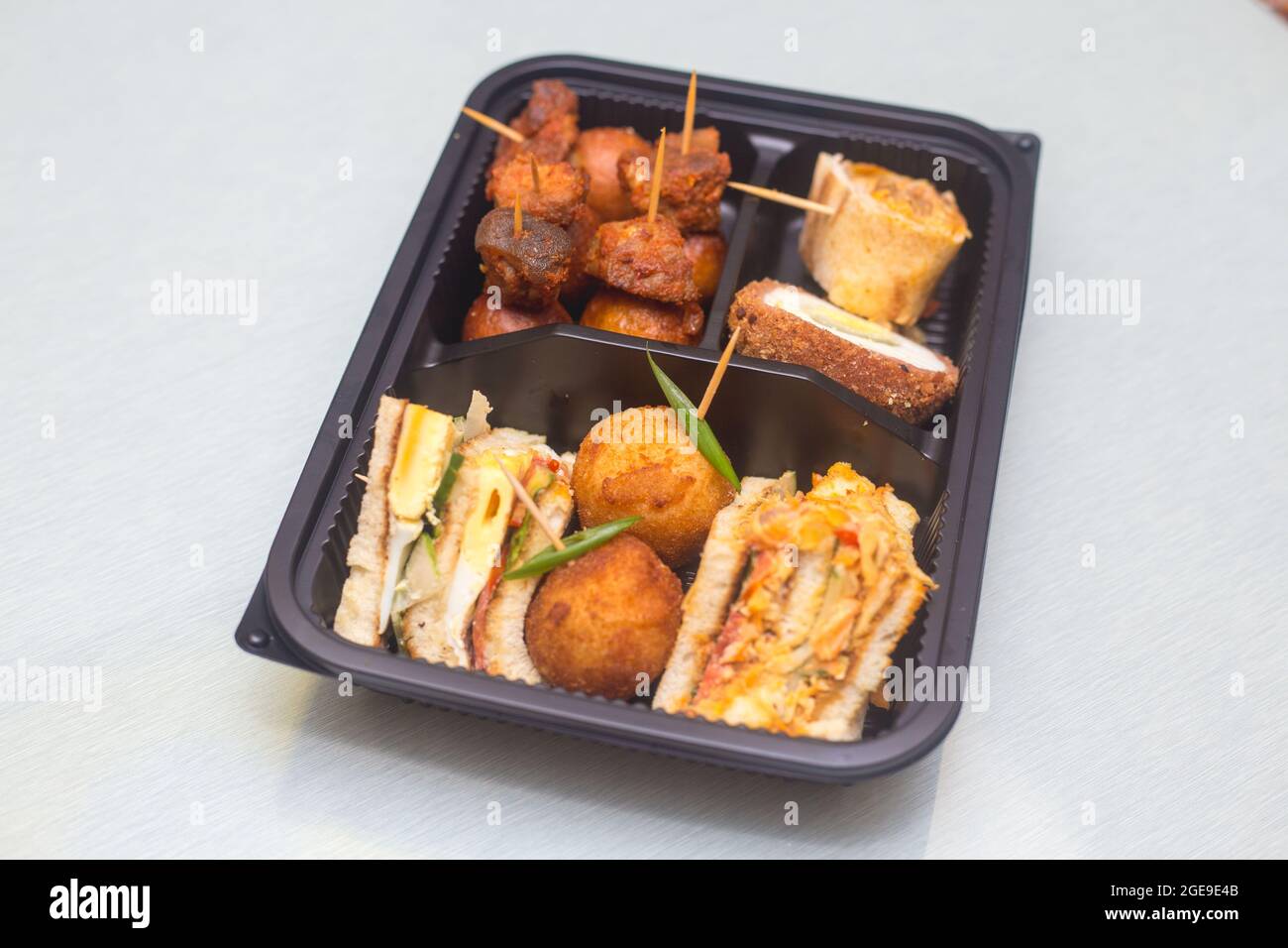 Combo meals consisting sliced cakes, scotch egg, small chops with ...