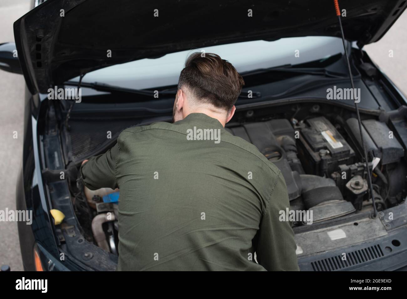 Back view of driver standing near car with open hood Stock Photo - Alamy