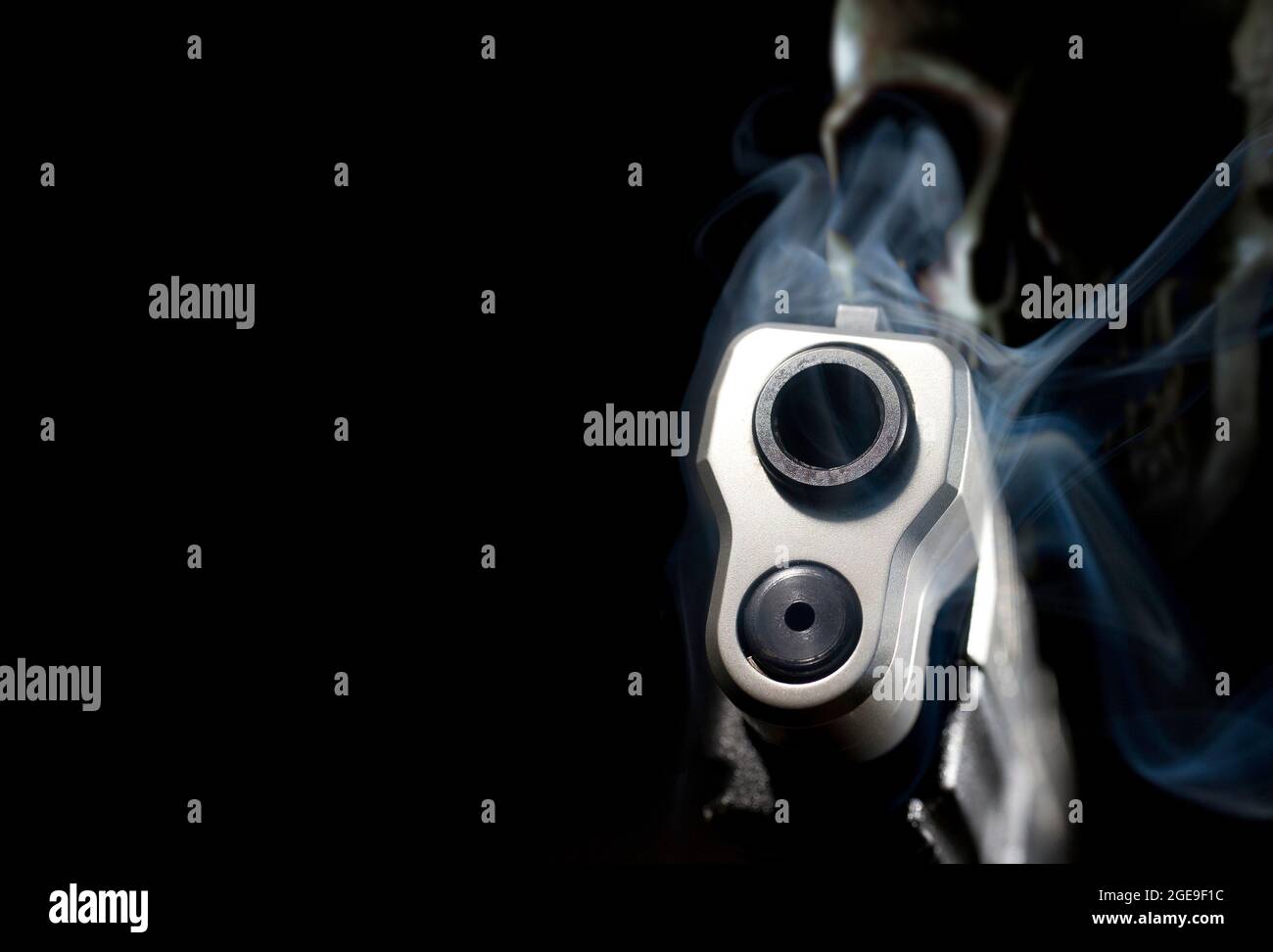 Skull behind a smoking semi automatic handgun as a 3D illustration of a ...