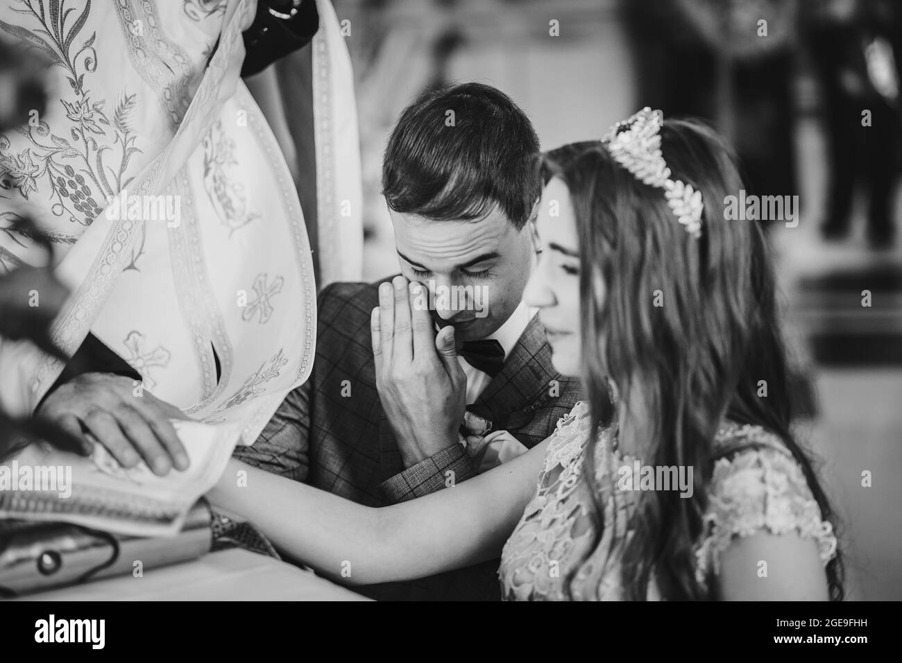 Stylish emotional bride and groom making oaths and holding hands on ...