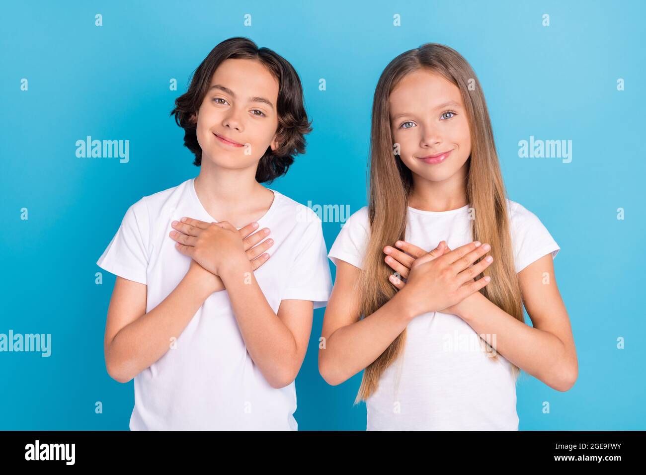 Photo portrait children keeping hands together hands on chest isolated ...