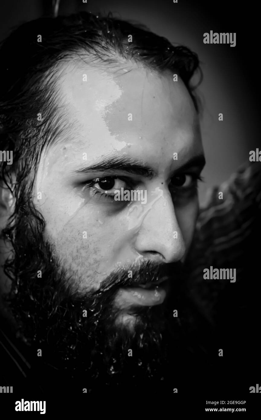 Black and white very close-up portrait of a young bearded man with ...