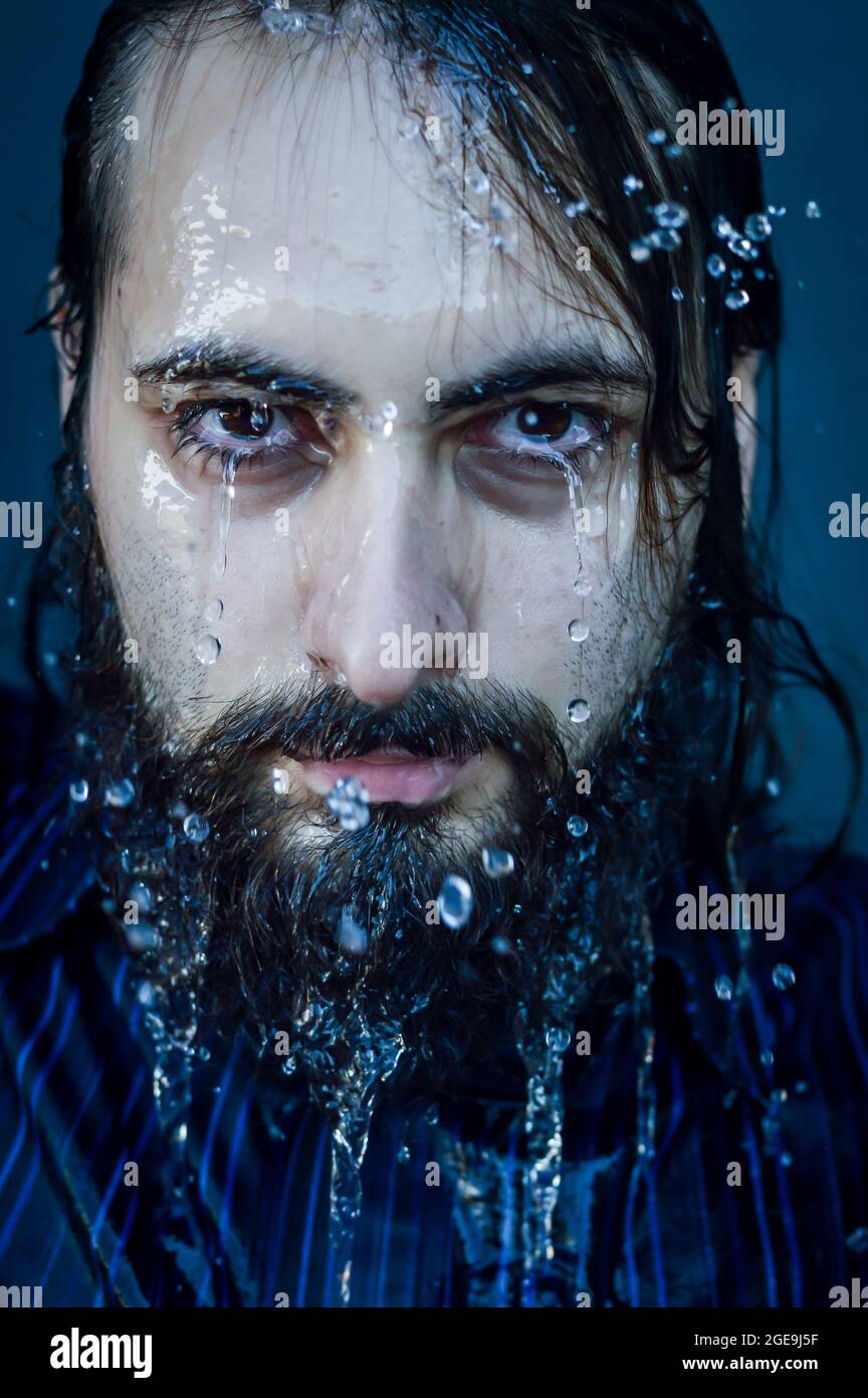 close-up portrait of a young bearded man with an intense gaze with ...