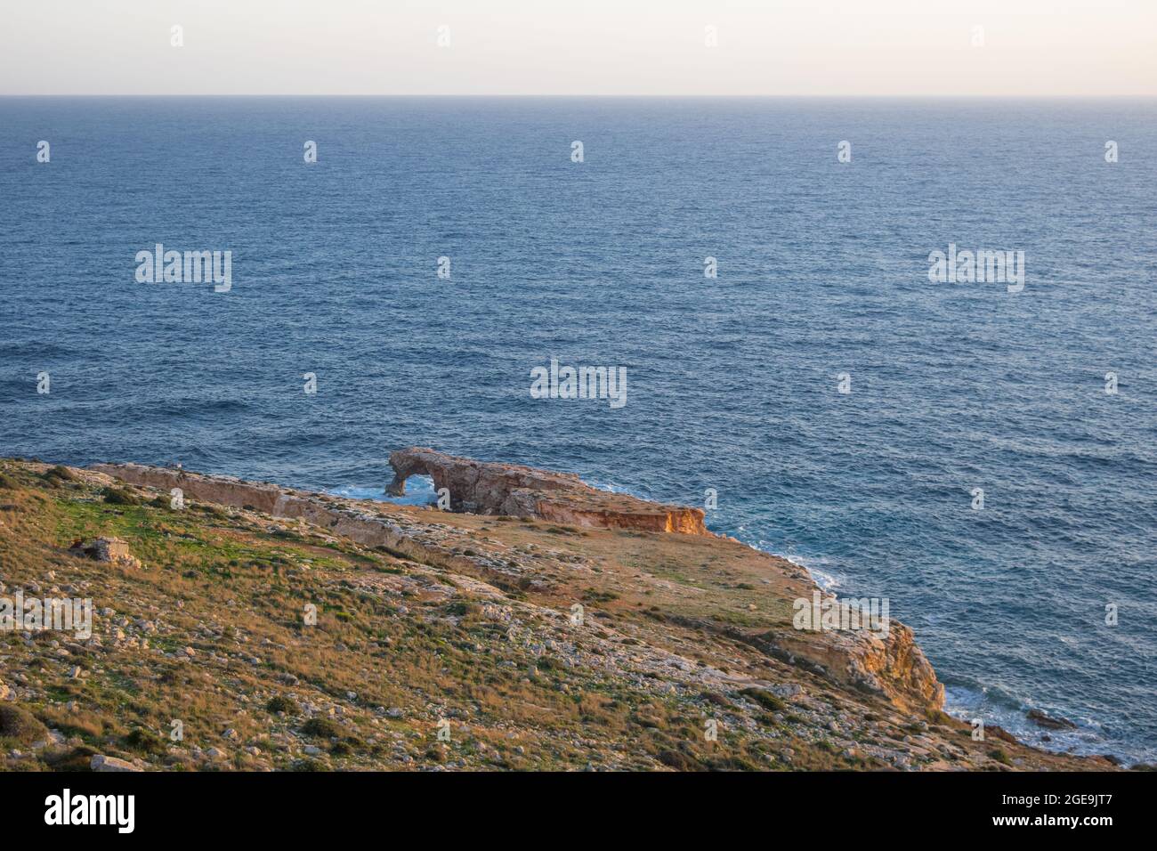 Natural sea arch formed by sea erosion at the tip of a headland called ...