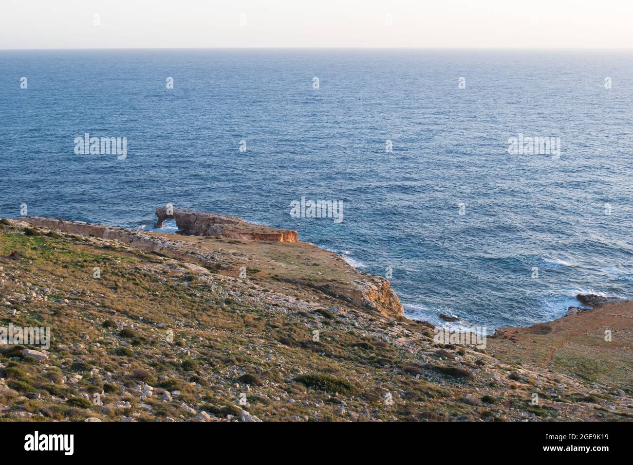 Natural sea arch formed by sea erosion at the tip of a headland called ...