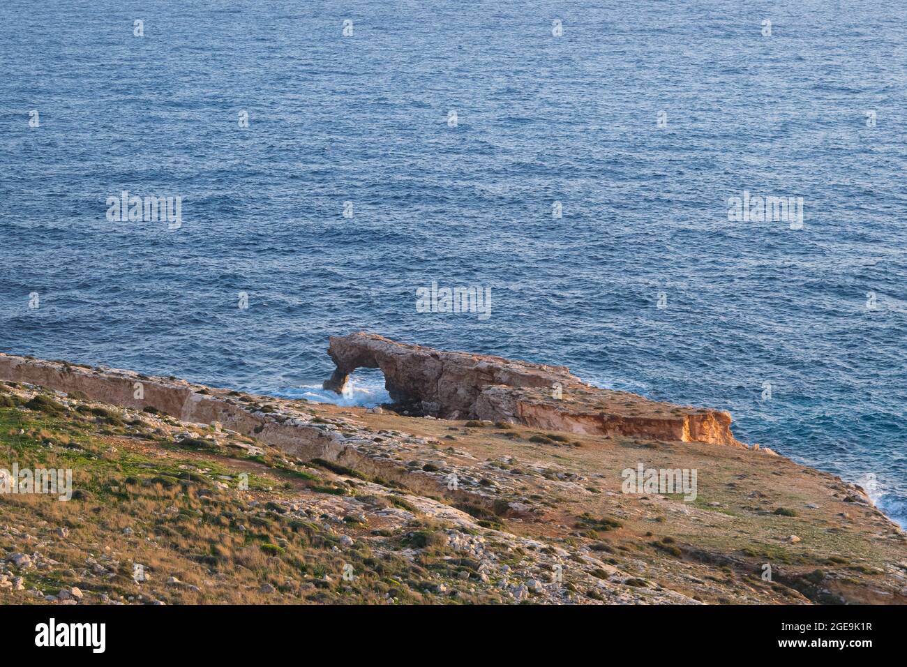 Natural sea arch formed by sea erosion at the tip of a headland called ...