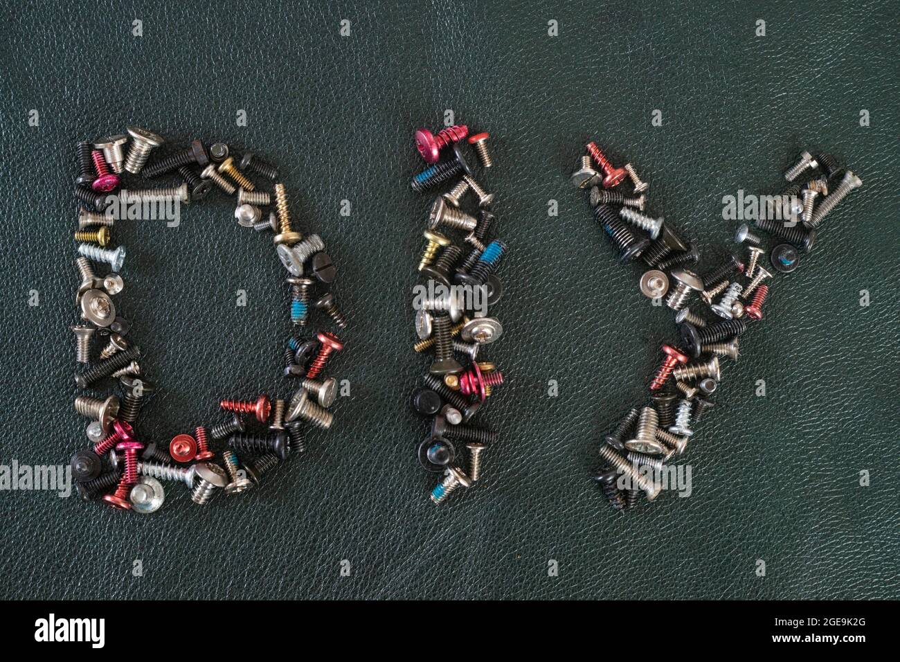 DIY written with tiny metal screws on black leather texture Stock Photo ...