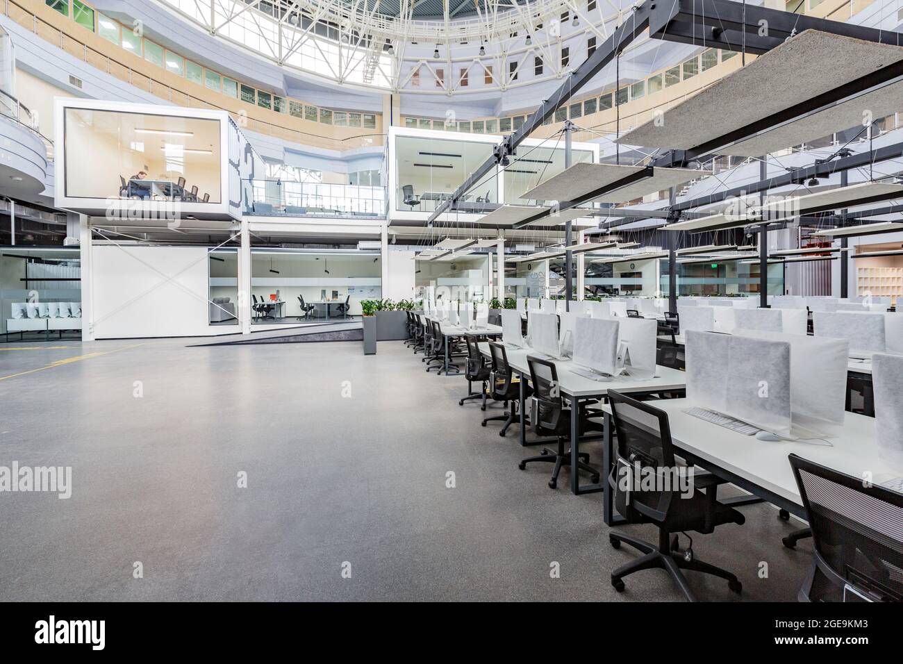 Interior of empty coworking space with covered computers Stock Photo ...