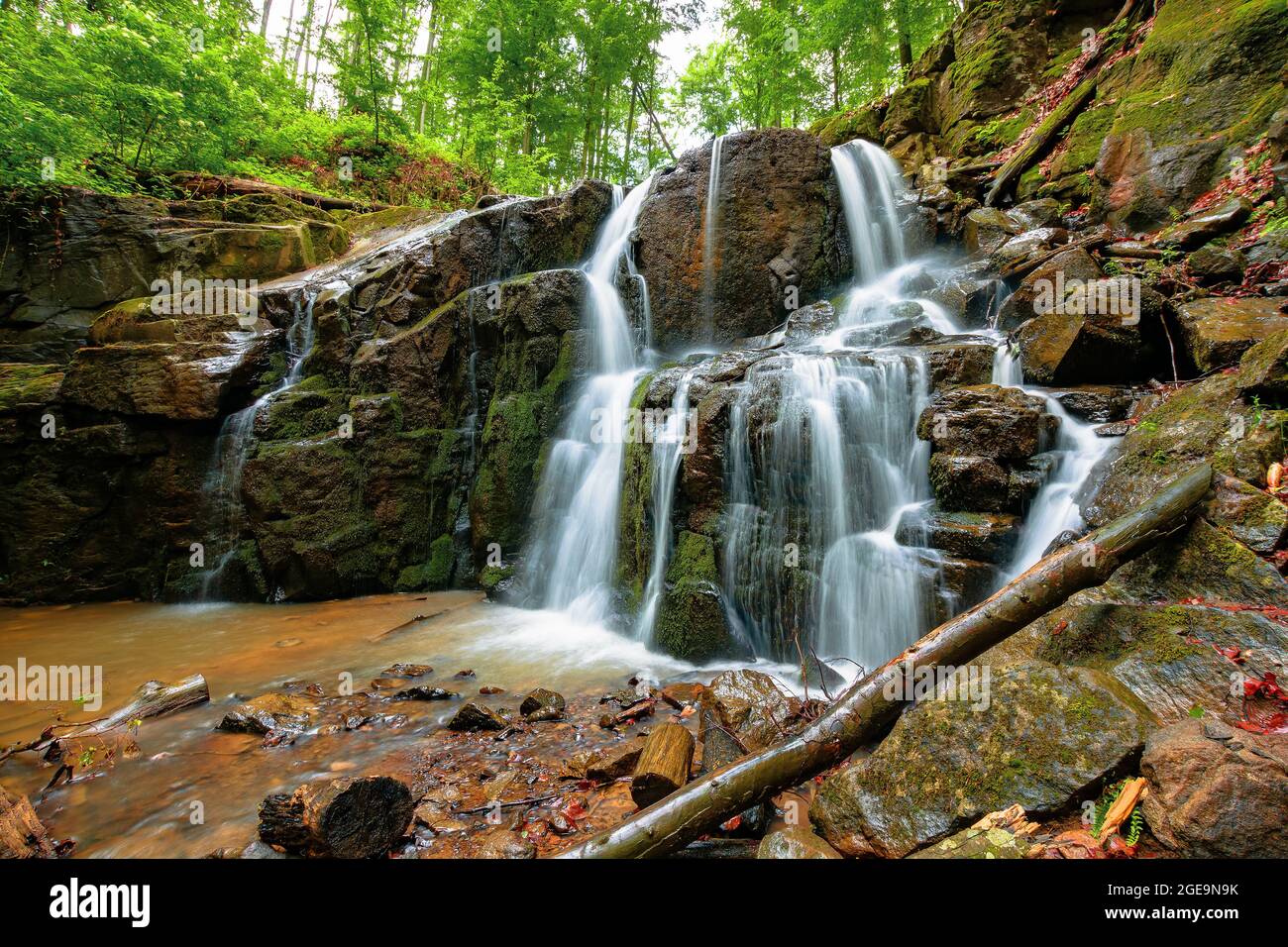 landscape with waterfall in spring. powerful water flow comes out of ...