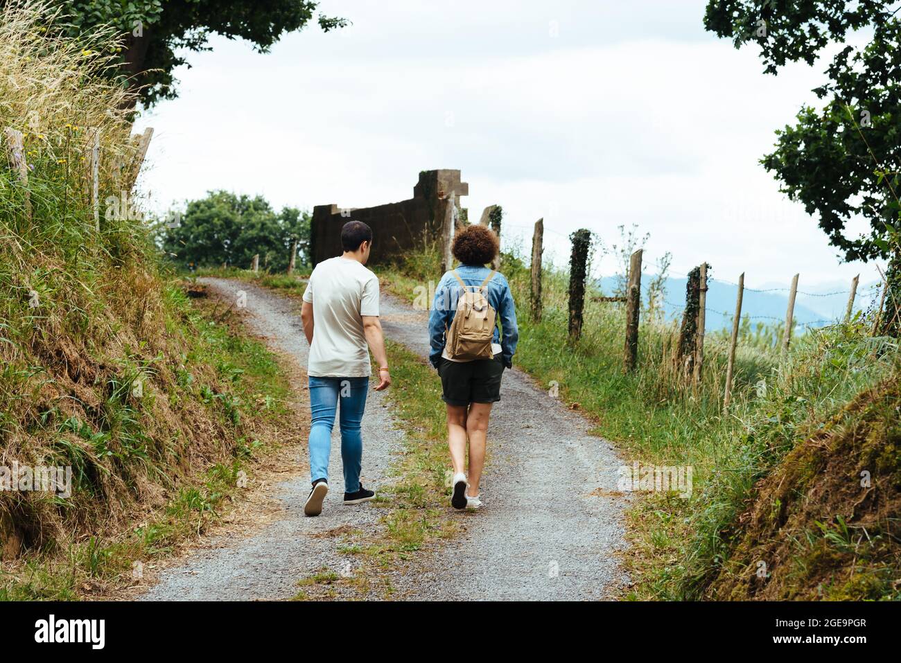 Rear view of mother and teenager son walking on rural footpath. Family ...