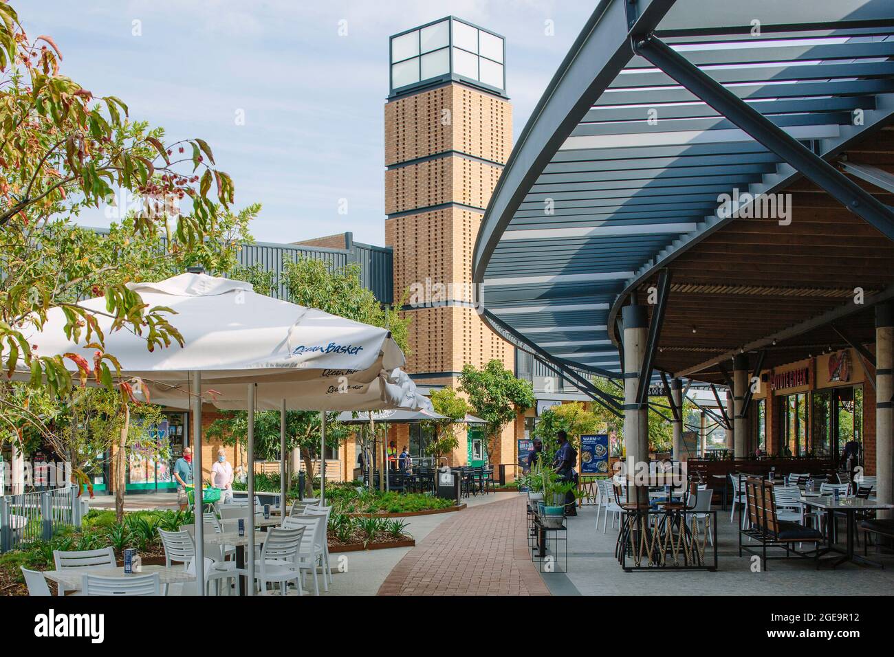 Walkway, portico landscaping and restaurant seating, with tower beyond ...