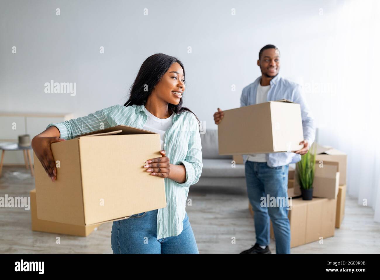 Relocation and apartment rent. Loving black couple carrying carton ...