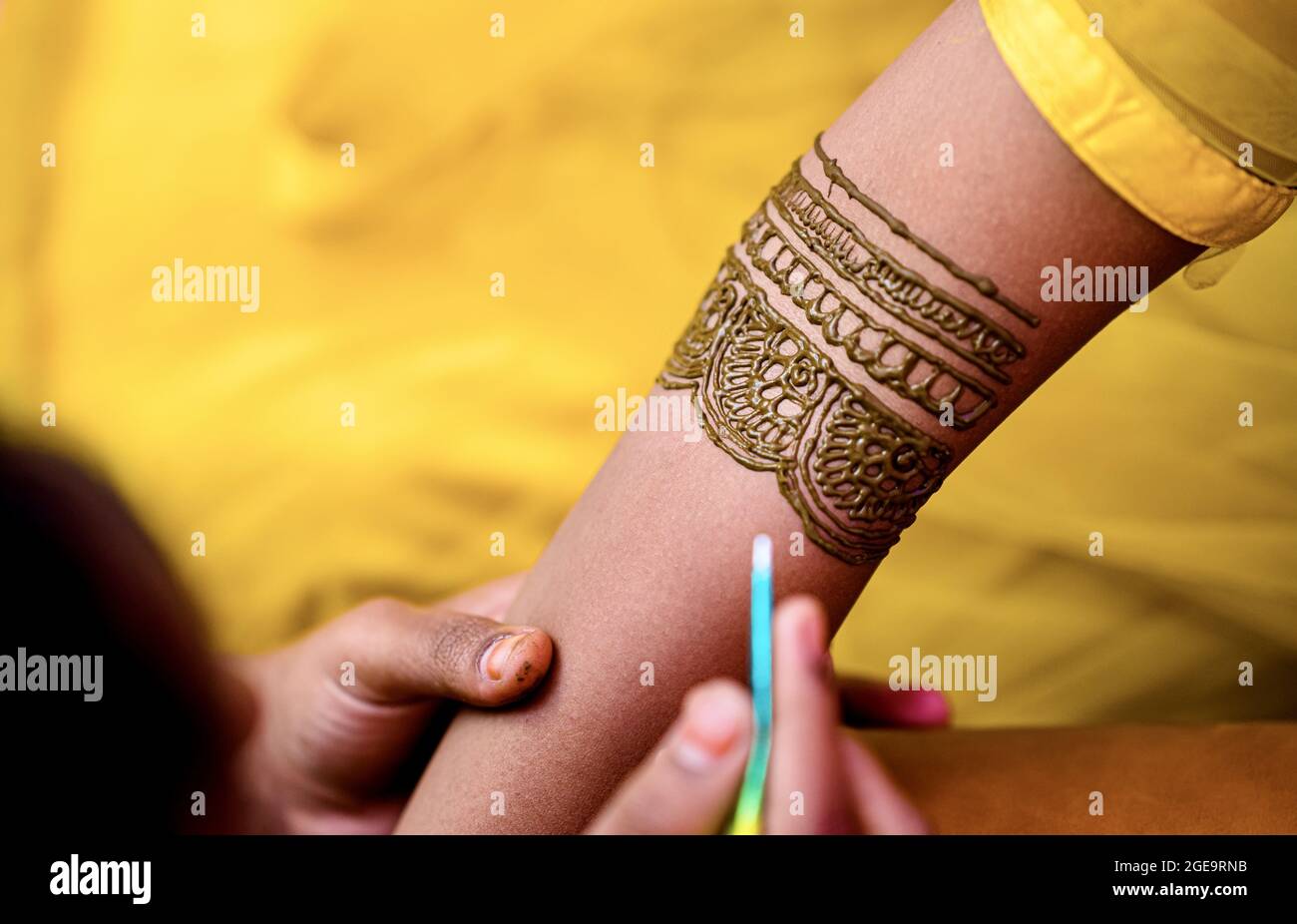 View of a woman drawing traditional Henna Mehandi body art on a hand ...