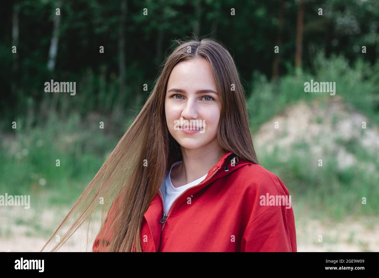 Candid portrait of a young caucasian woman in red clothes playing with ...
