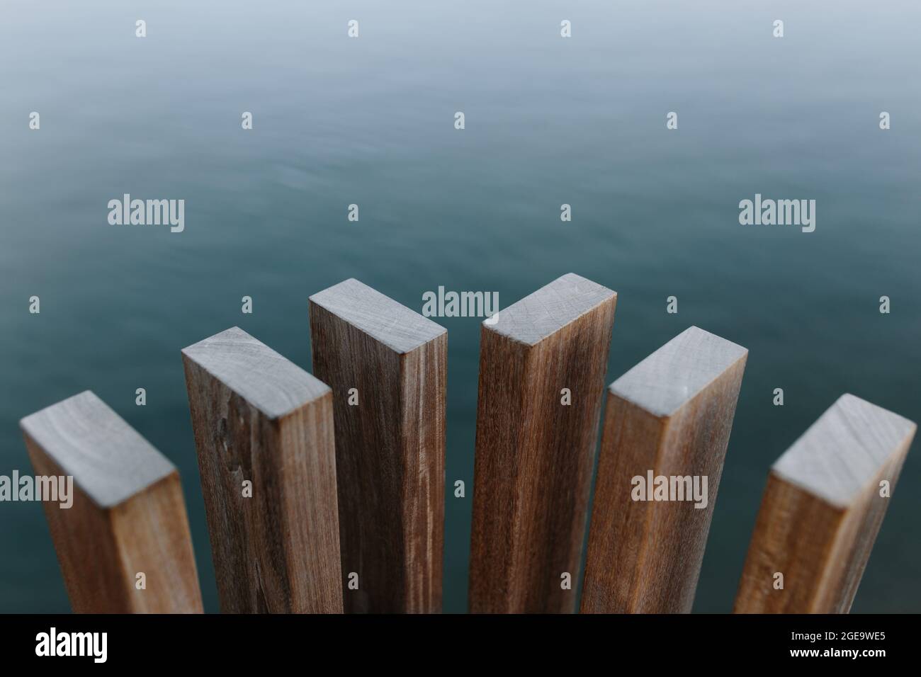 High angle of modern wooden beams placed near pond with calm water at ...
