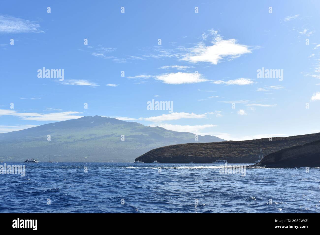 Molokini Crater rock emerging from the Pacific Ocean with mountains in ...