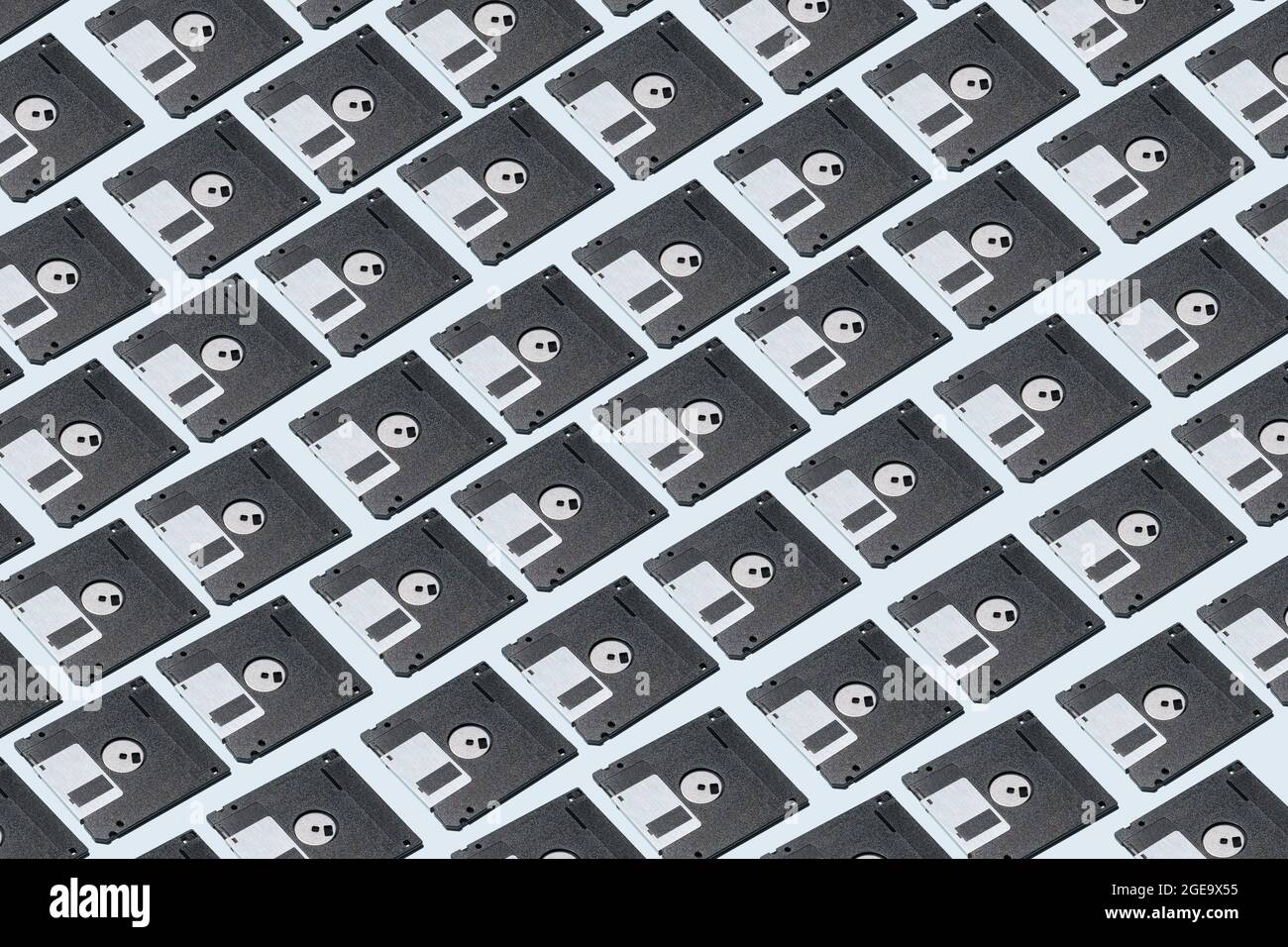 From above of old fashioned black diskettes placed in even rows on blue ...