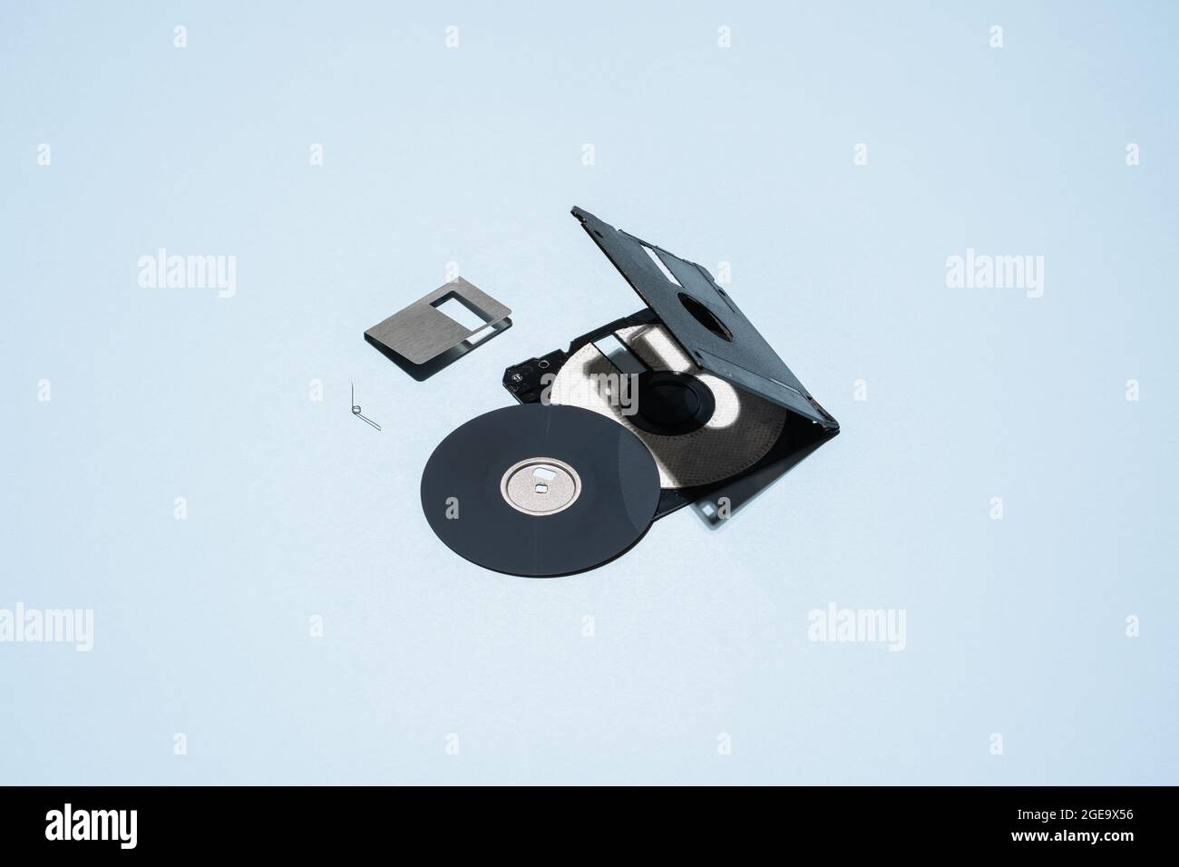 High angle of parts of old fashioned floppy disk arranged on blue ...