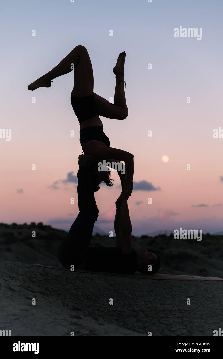 Side view of flexible Woman balancing upside down while practicing ...