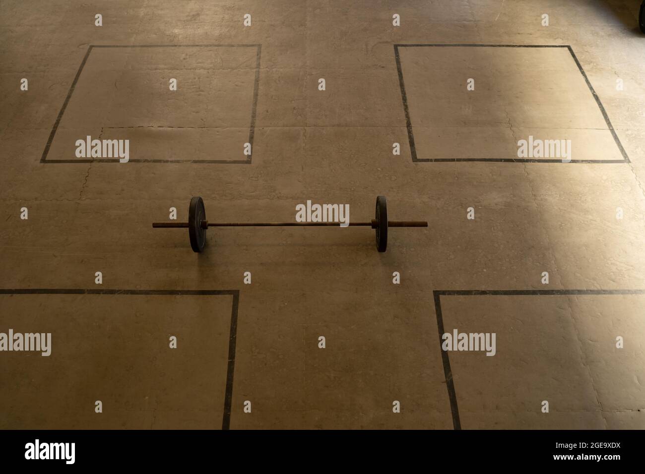 From above of heavy metal barbell placed on floor in spacious facility ...